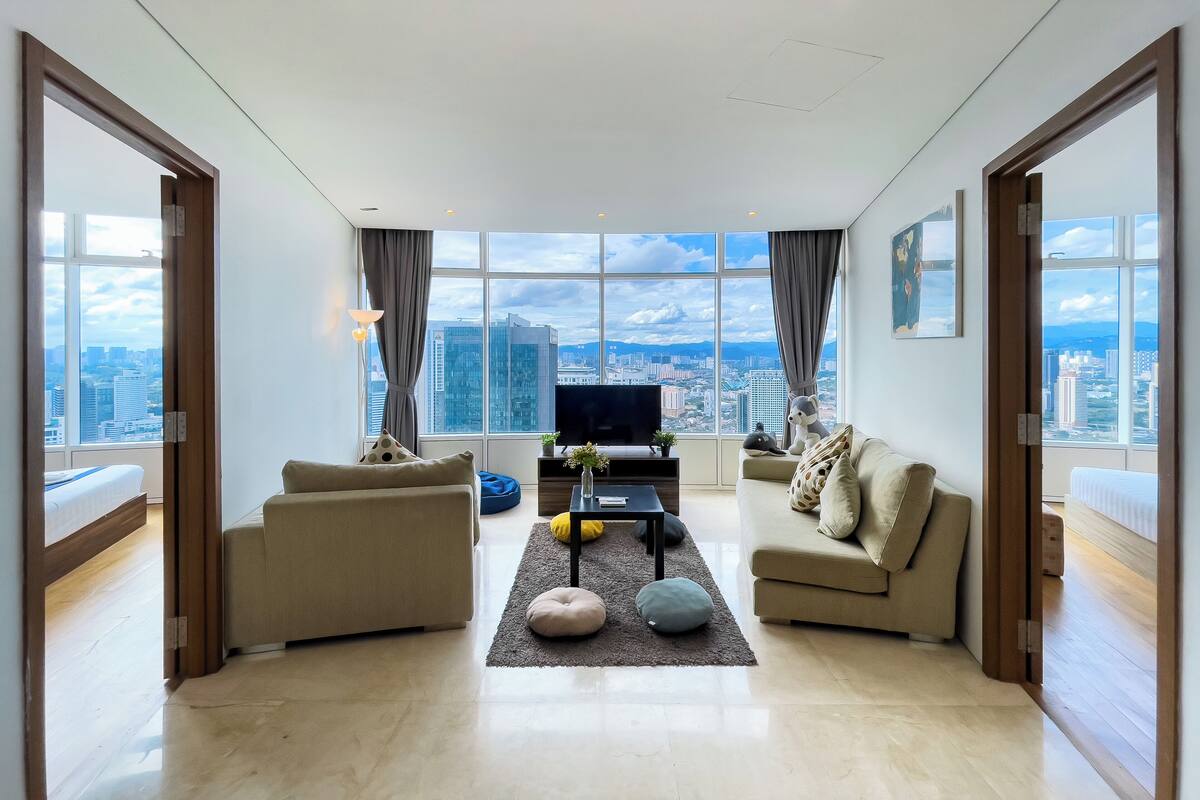 Uma sala de estar moderna com uma janela grande, uma televisão de tela plana e dois sofás.