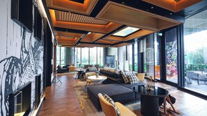 Uma sala de estar moderna com um sofá seccional, uma mesa de centro redonda e uma grande janela com vista para o exterior.