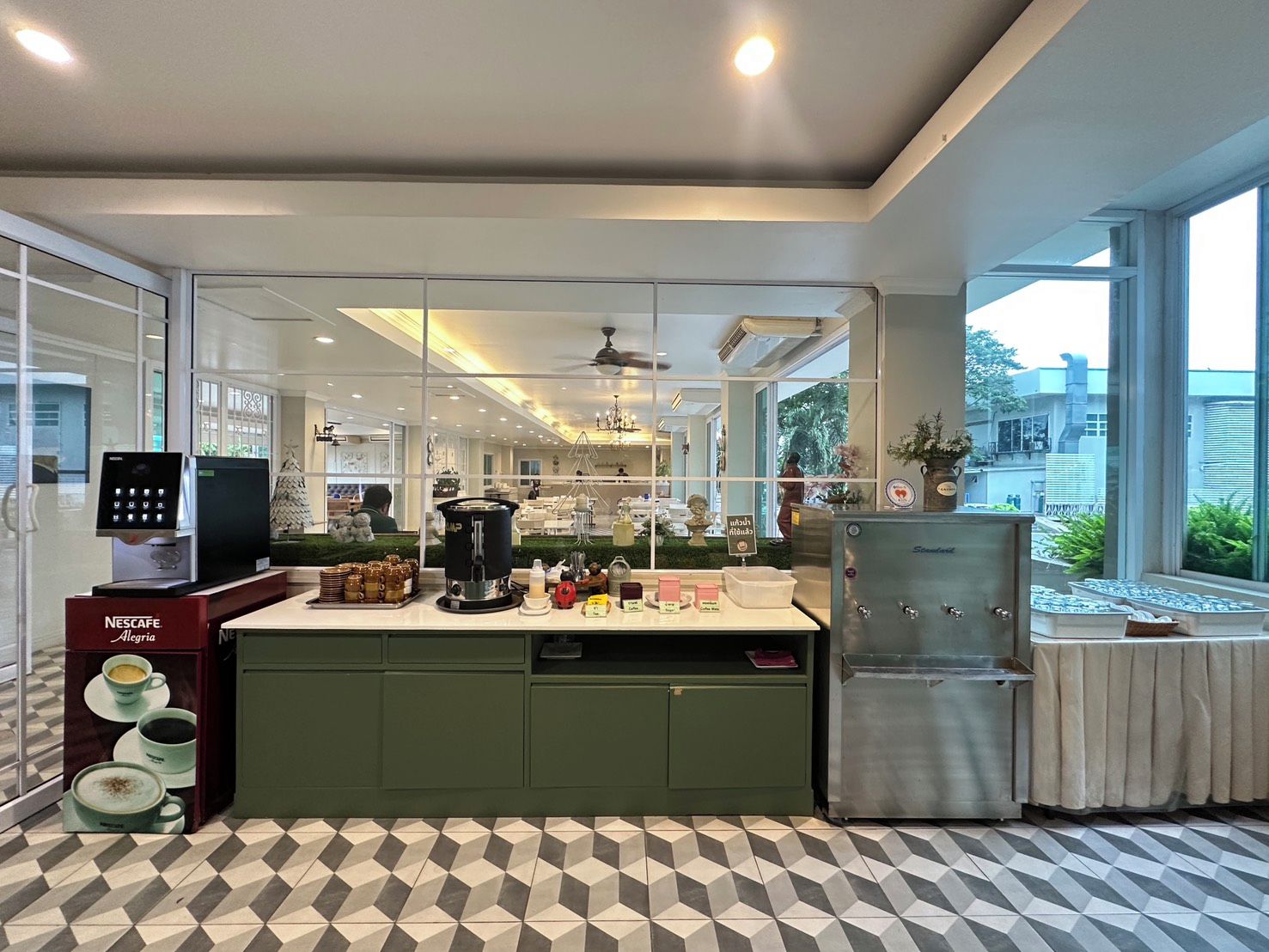 Uma cozinha moderna com máquina de café, geladeira e bancada com diversos itens.