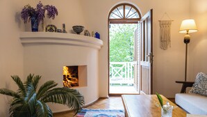 Uma sala de estar aconchegante com lareira, um sofá, uma mesa de centro e vista para o exterior.