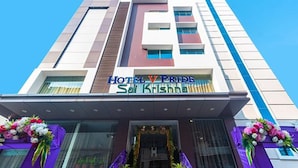 Hotel chamado "Hotel Pride Sai Krishna", com fachada moderna e entrada imponente.