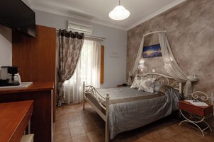 Quarto com cama, mesa de cabeceira e um quadro na parede.