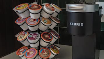 Máquina de café e porta-copos com vários copos de café.