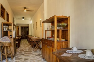 Um corredor estreito com mobiliário de madeira e um espaço para buffet.