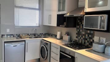 Apartamento luxo, vista para a cidade | Cozinha privada | Geladeira, micro-ondas, fogão, cooktop