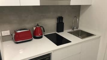 Um frigorífico, um micro-ondas, uma torradeira, utensílios de cozinha