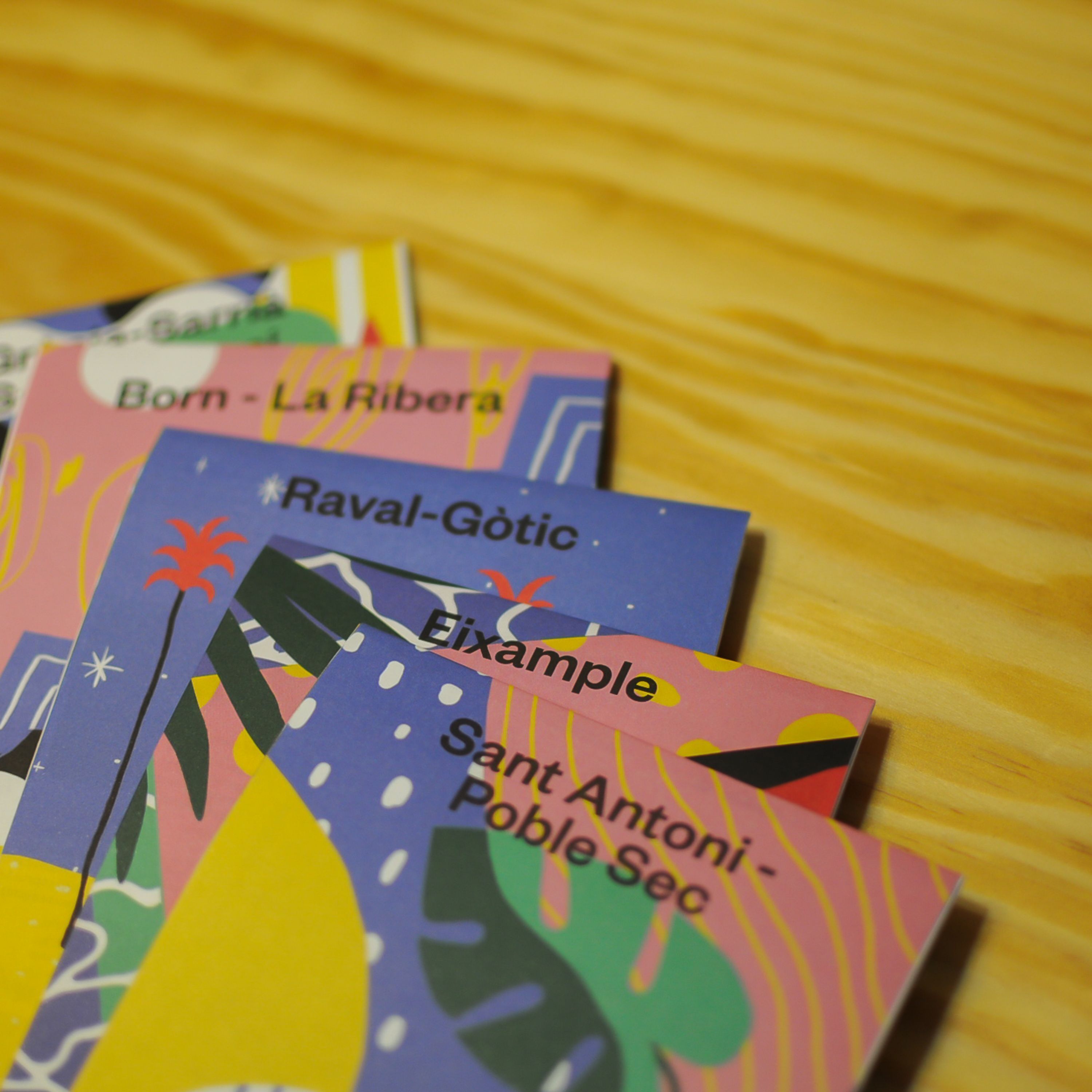 Um conjunto de cartas coloridas com nomes e símbolos sobre uma superfície de madeira.