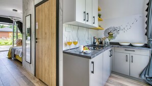 Uma cozinha moderna com detalhes em mármore, porta de madeira e vista para o exterior.