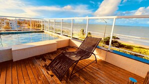 Piscina externa com vista para o oceano e para a paisagem urbana.