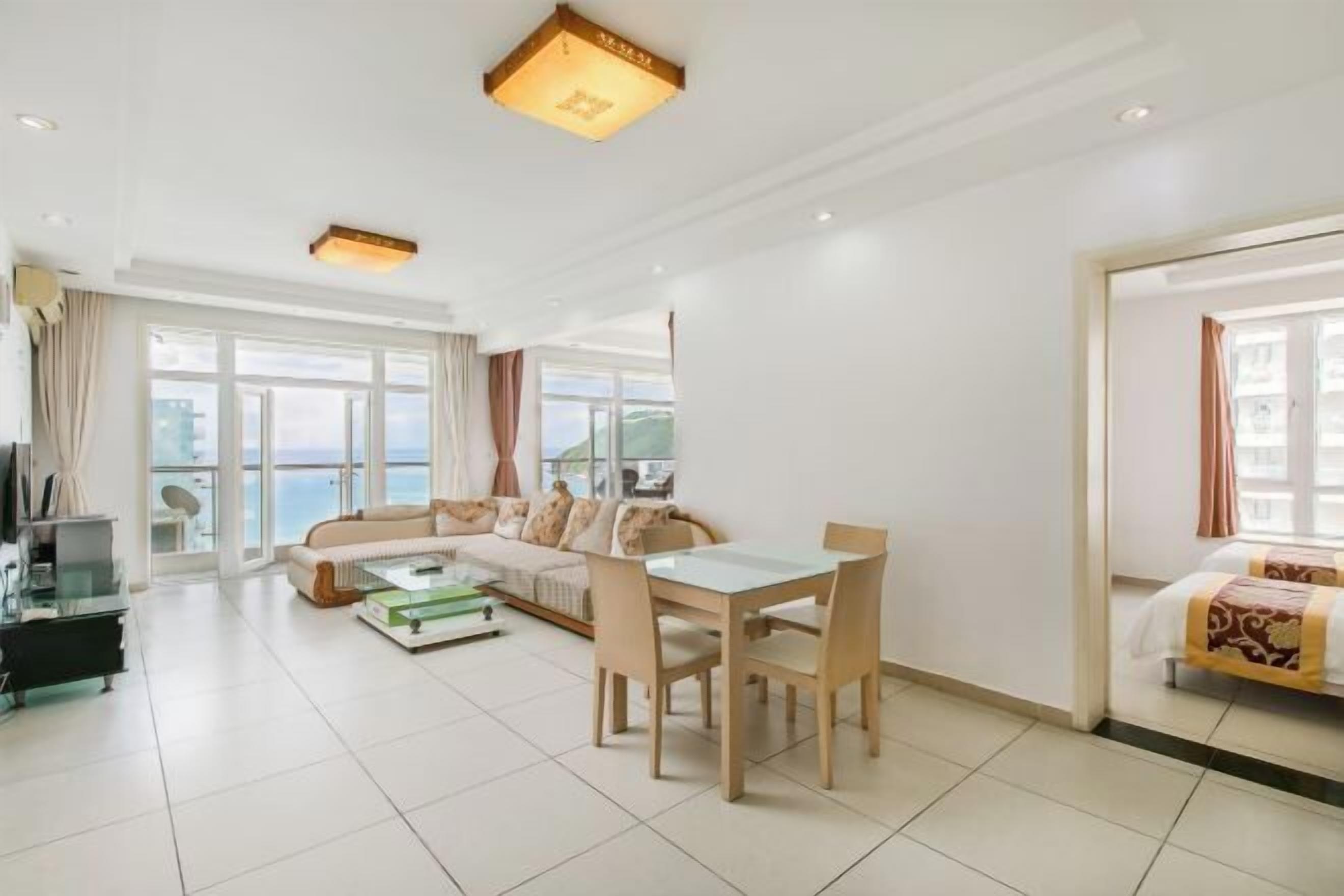 Quarto de hotel moderno com área de refeições, sofá e cama.