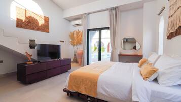 Quarto moderno com cama, televisão sobre cômoda e vista para uma piscina ao ar livre.