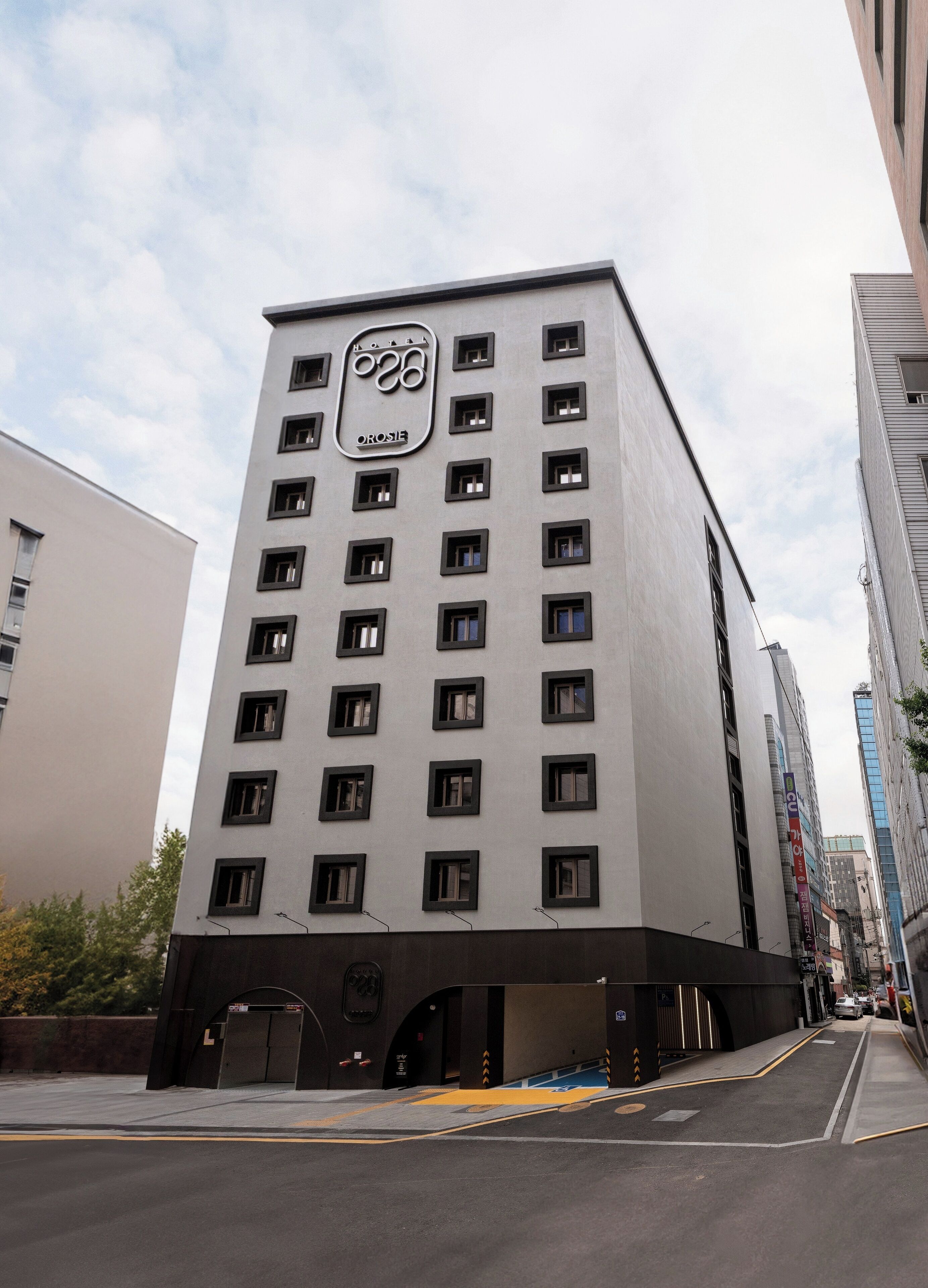 Um edifício de hotel moderno com um logotipo marcante e várias janelas.