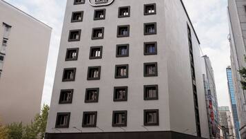 Um edifício de hotel moderno com um logotipo marcante e várias janelas.