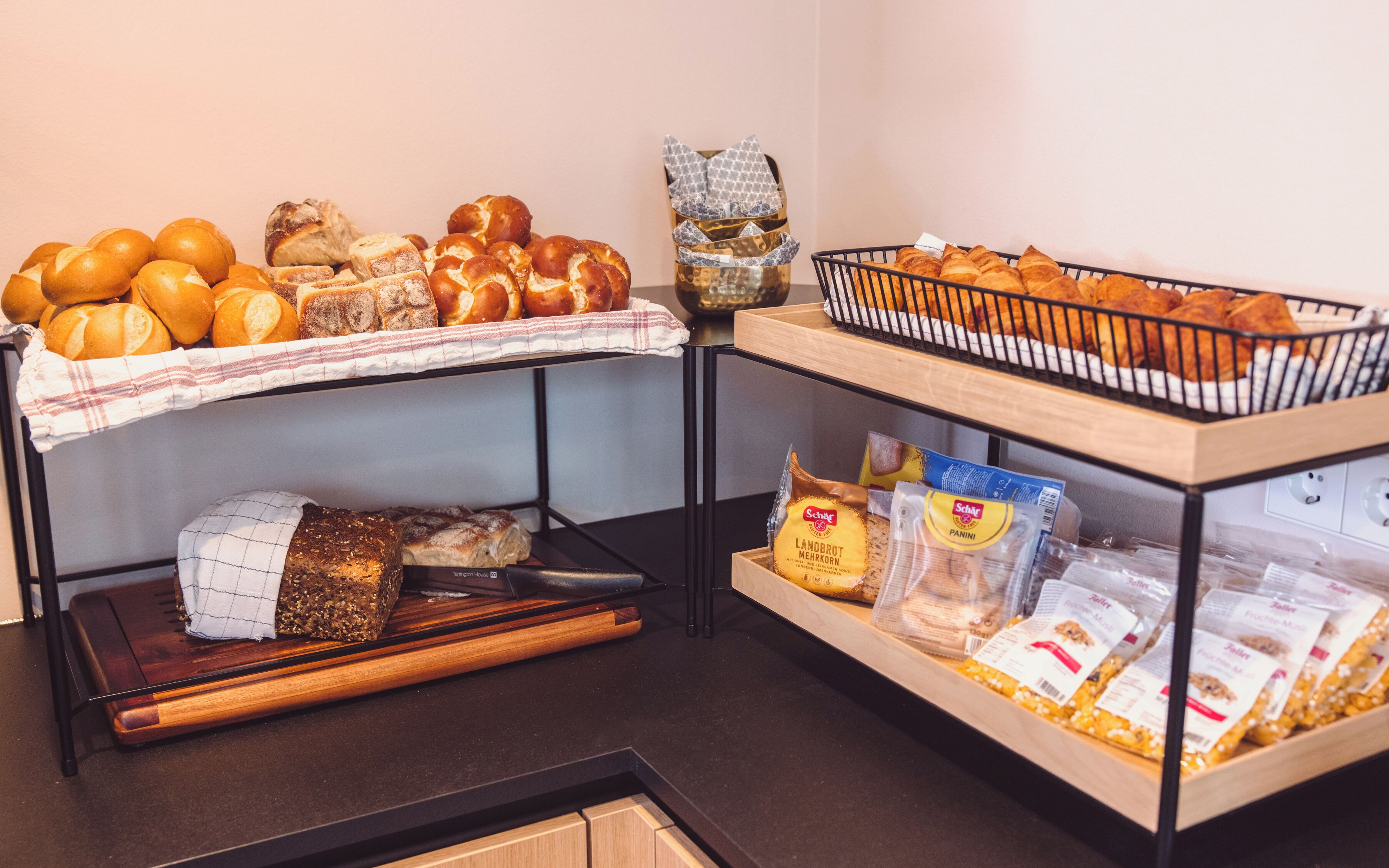 Vitrine de padaria com diversos pães e doces.