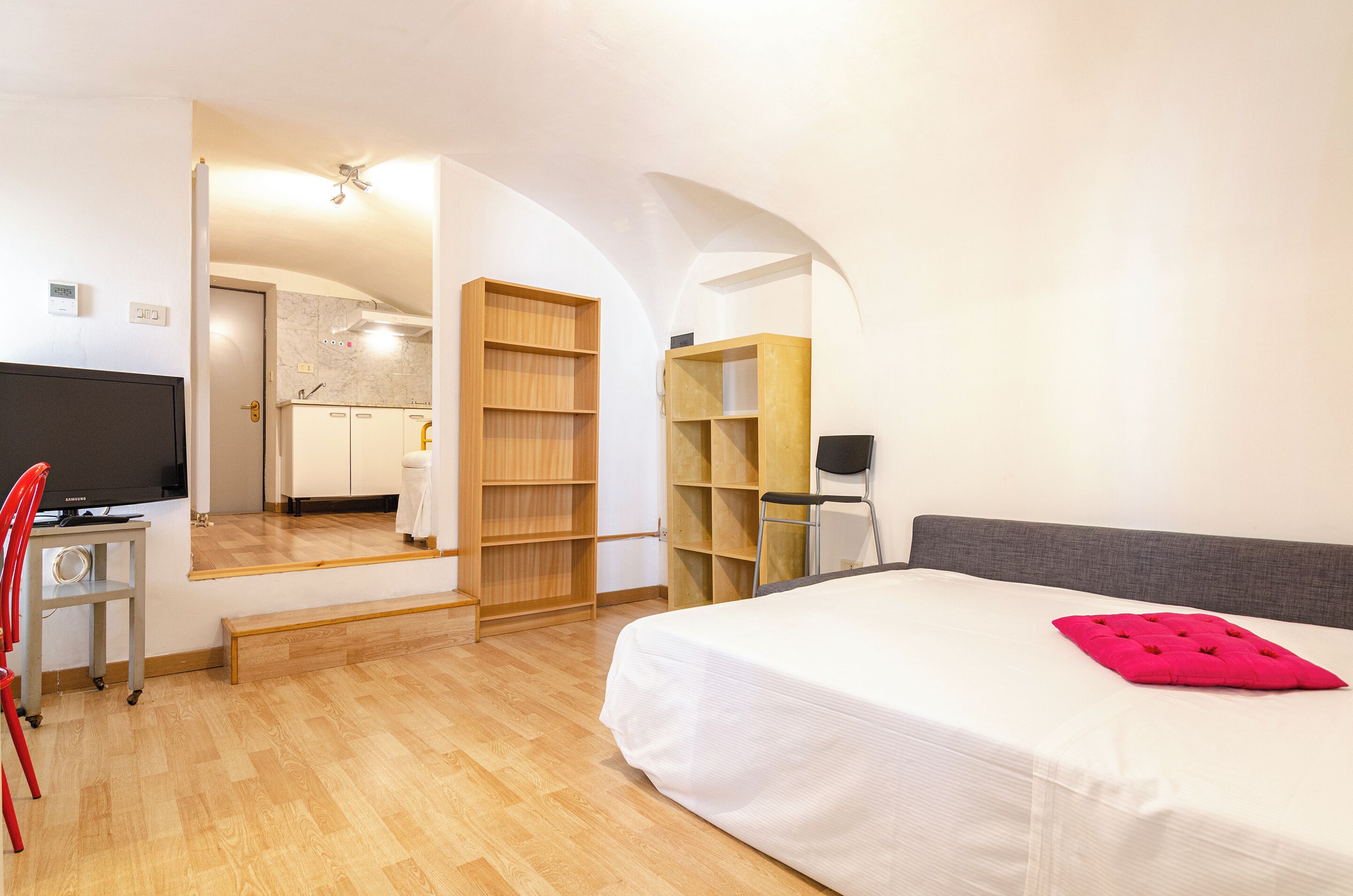 Quarto com uma cama, escrivaninha, cadeira e guarda-roupa.