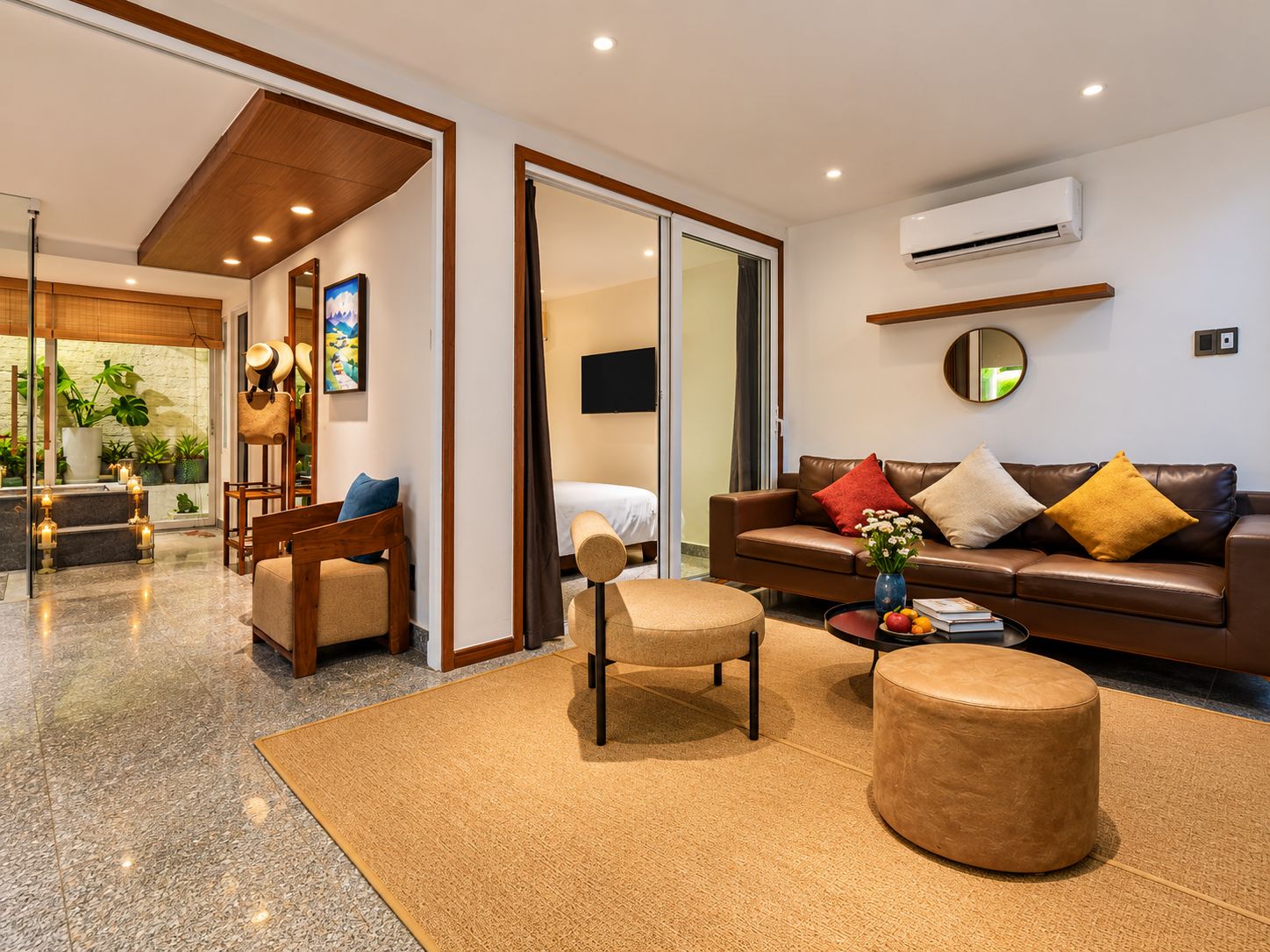 Uma sala de estar moderna com sofá, poltronas, mesa de centro e televisão.