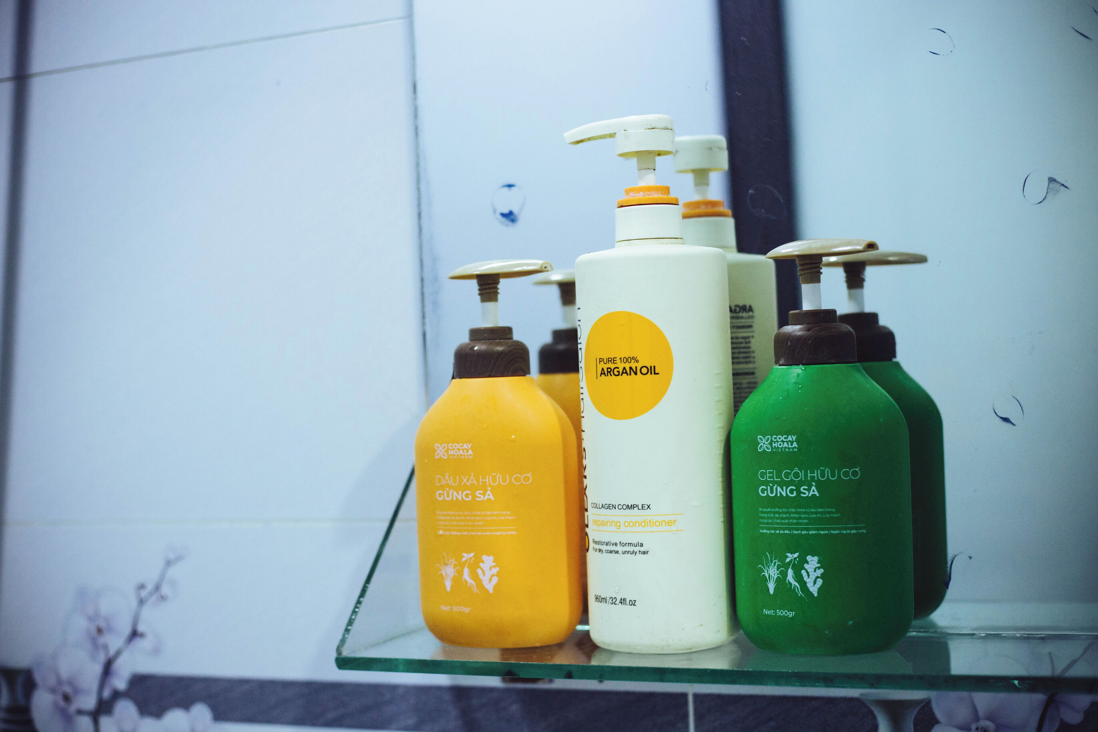 Uma prateleira com quatro embalagens de produtos para cabelo.