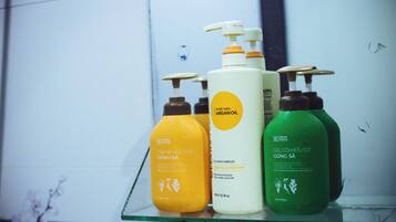 Uma prateleira com quatro embalagens de produtos para cabelo.