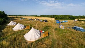 Um camping com várias barracas e céu limpo.