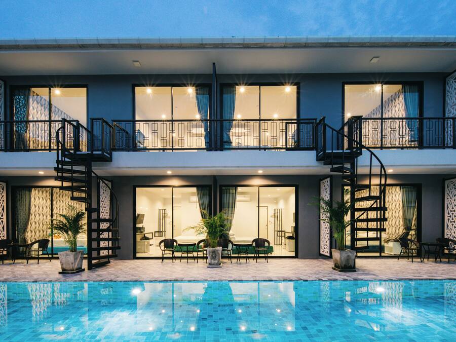 Um hotel moderno com piscina, área de estar ao ar livre e varandas.