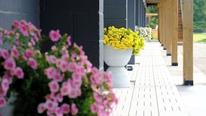 Uma galeria coberta com plantas em vasos e estrutura de madeira.