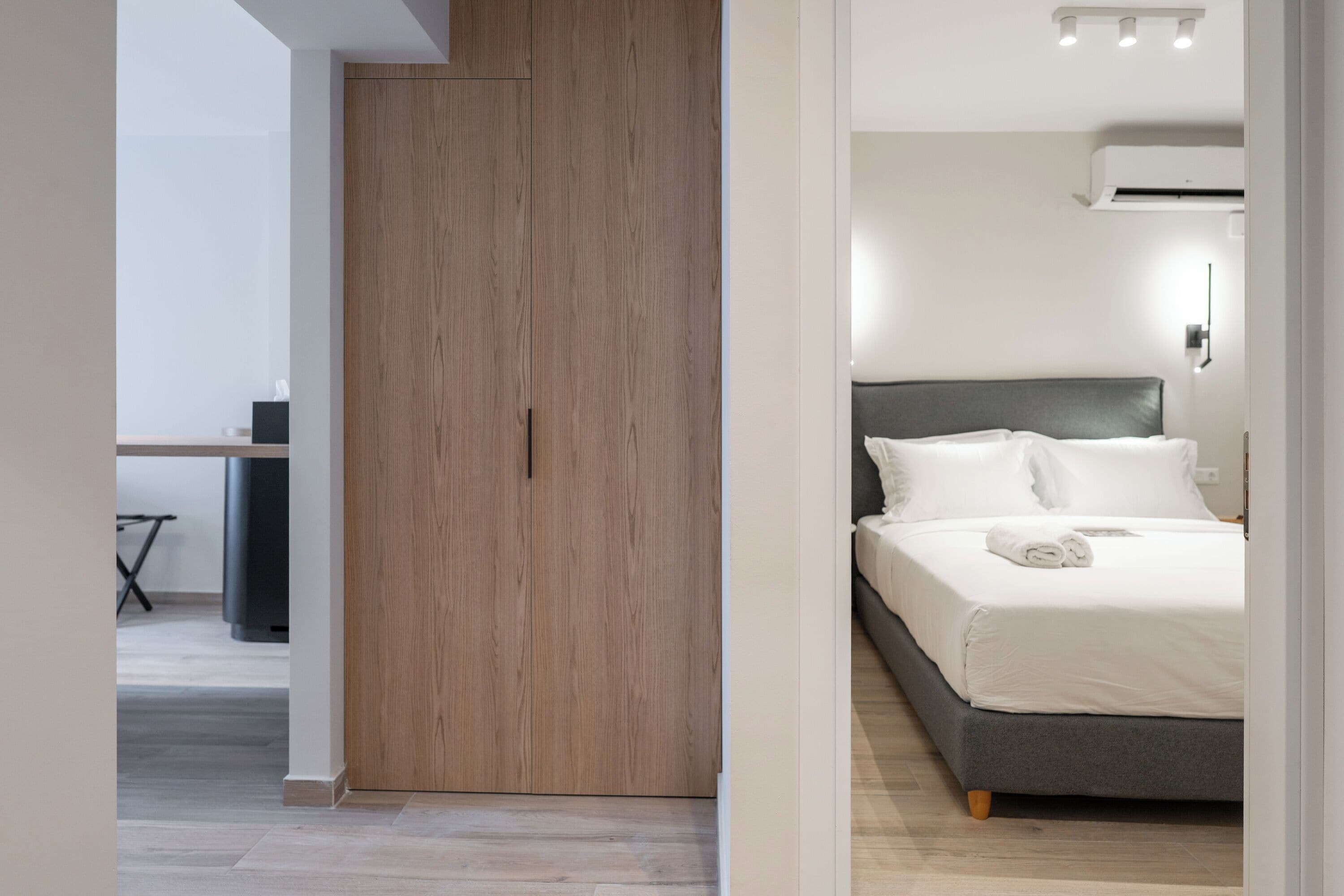 Quarto com cama, guarda-roupa e escrivaninha.