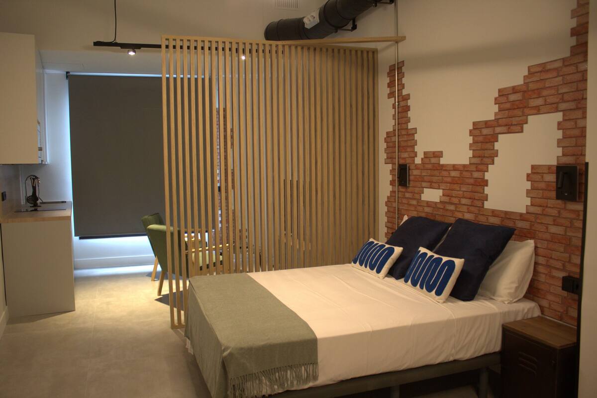 Um quarto moderno com uma cama, uma escrivaninha e uma cadeira.