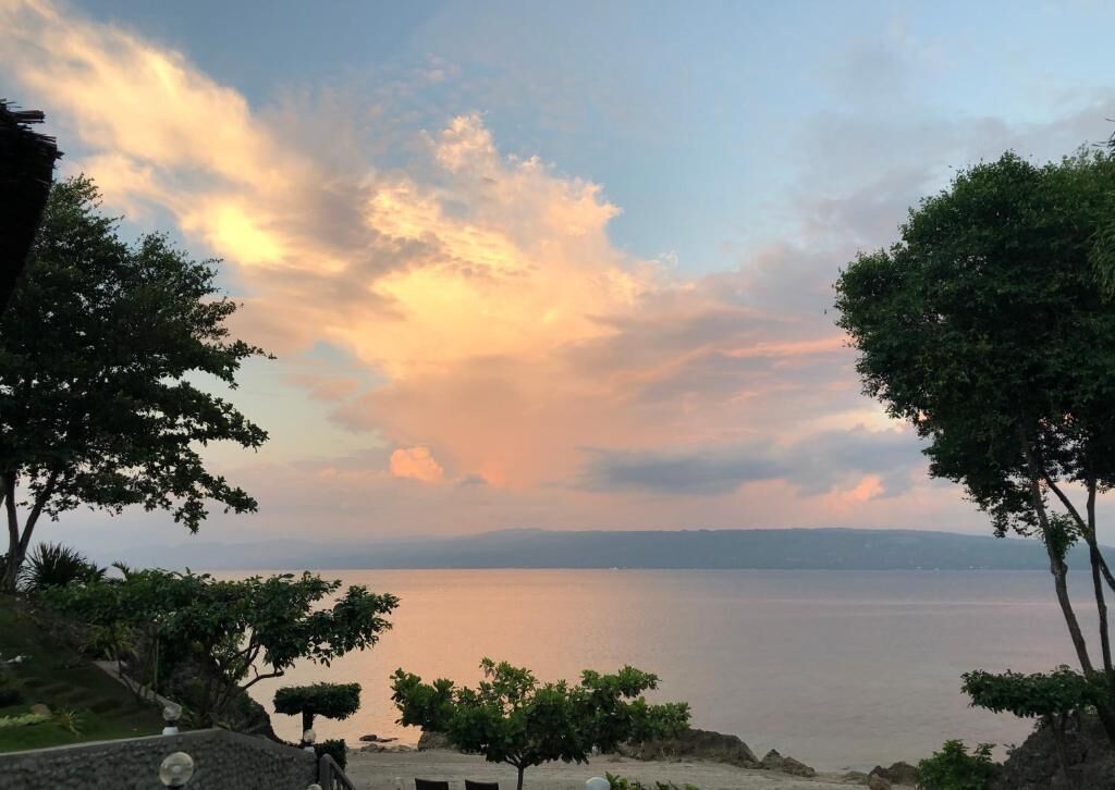 Paisagem costeira com vista para o mar e céu claro.