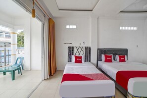 Quarto de hotel com duas camas, varanda e vista para o exterior.