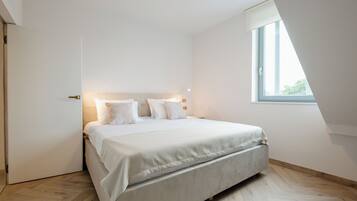 Quarto com uma cama grande, janela e porta.