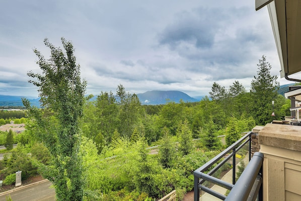 Uma varanda com vista para uma área arborizada e montanhas ao longe.