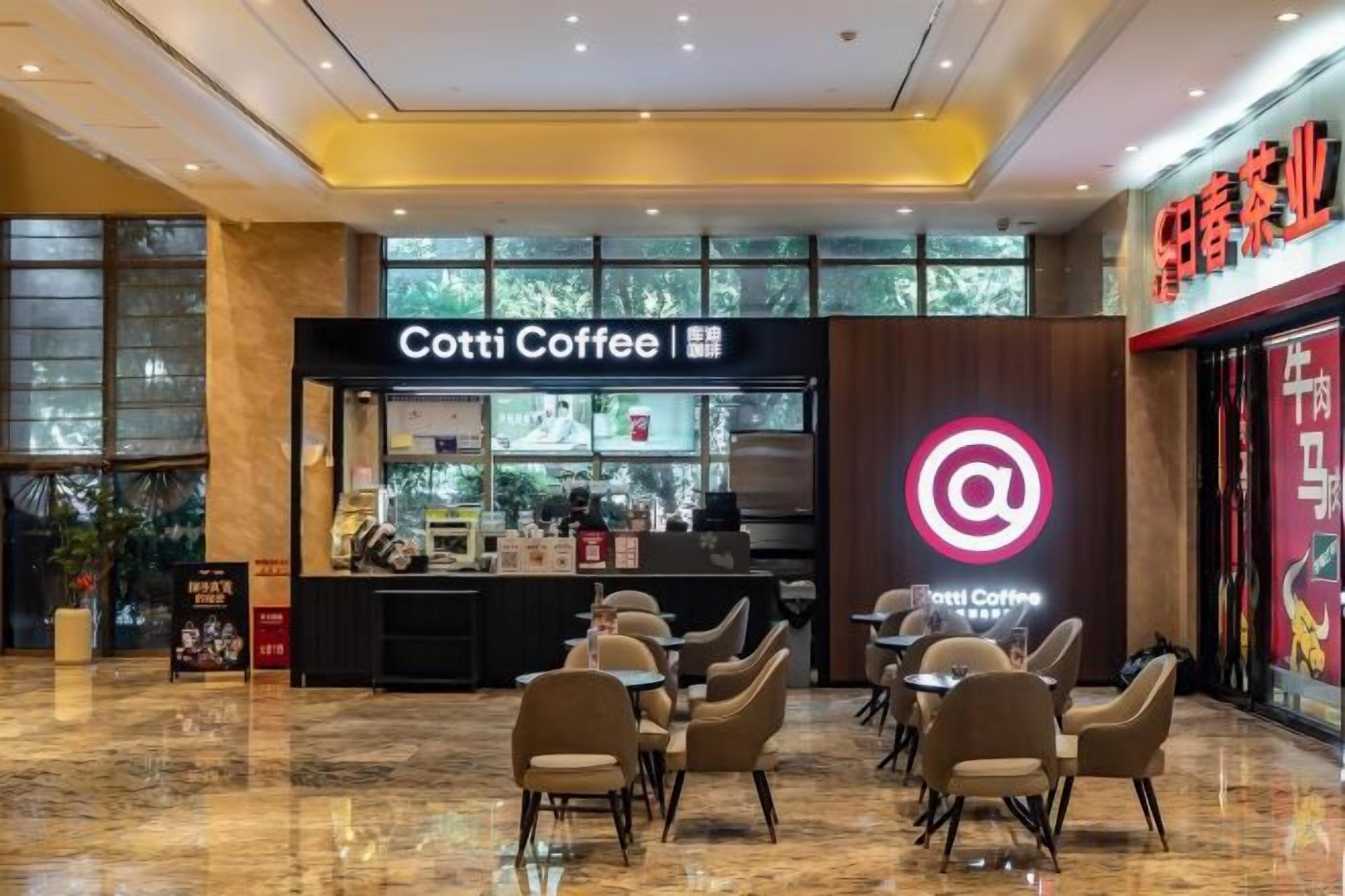 Uma cafeteria Cotti com balcão e área de estar em ambiente interno moderno.