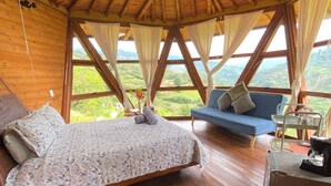 Uma cabana de madeira com uma cama, um sofá e uma mesa de centro.