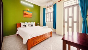 Quarto com cama de madeira, paredes verdes, um quadro e uma janela com cortinas.