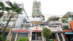 Um edifício com uma placa indicando 'Tin Phat Express' e outra para 'Chai Shop'.