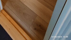 Um quarto com uma cama, uma cadeira e uma janela com cortinas.