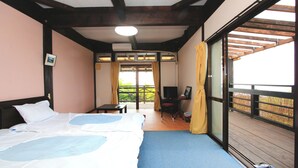 Quarto com duas camas, uma pequena escrivaninha, uma cadeira e varanda com vista.