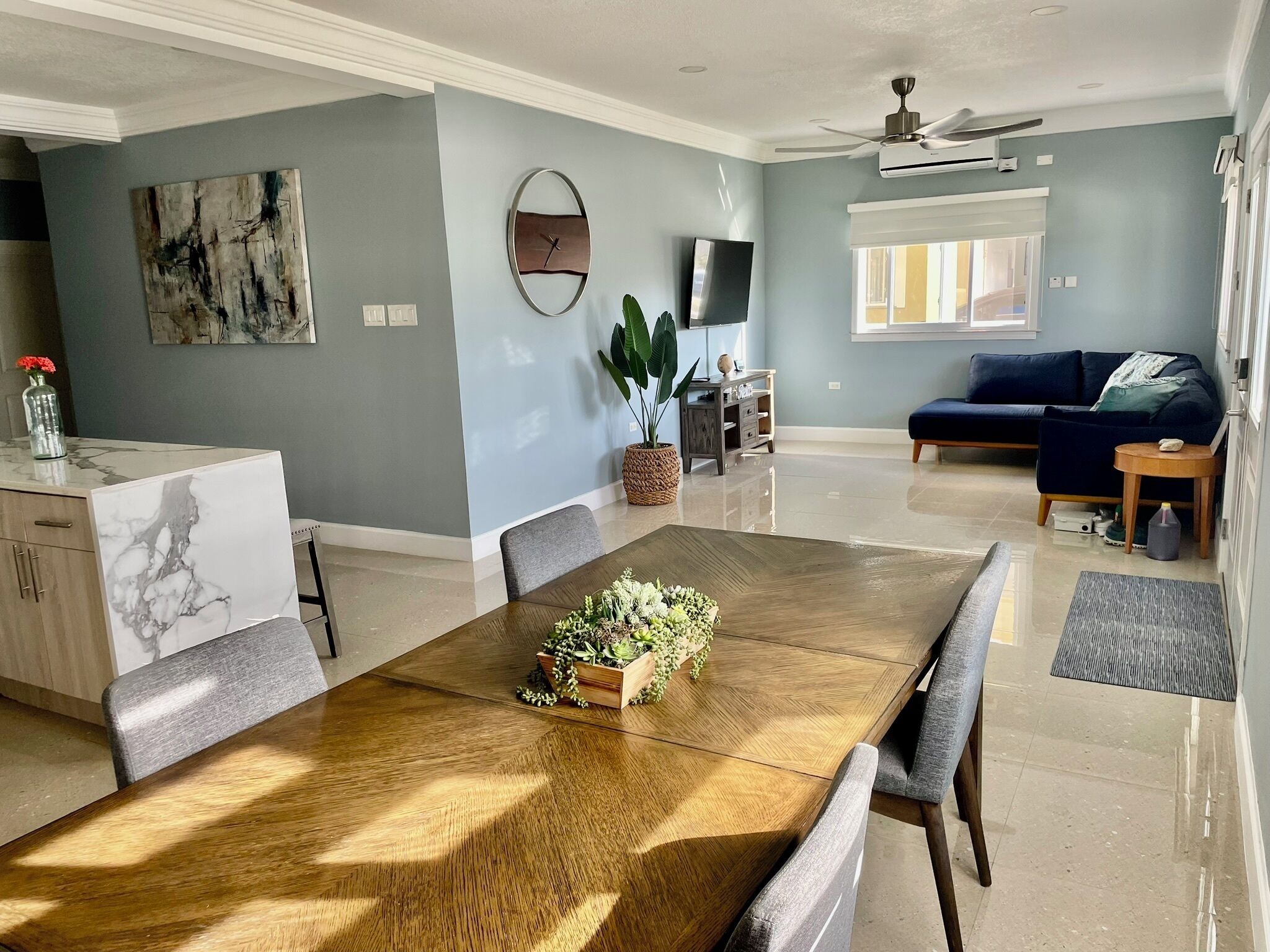 Uma sala de estar moderna com uma mesa de jantar, sofá e televisão.