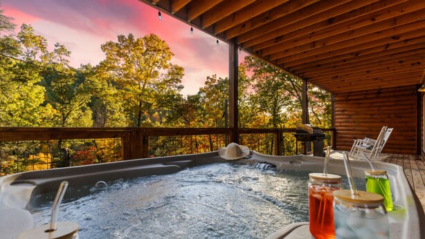 Hidromassagem com bebidas e vista para o pôr do sol.