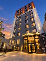 Um hotel moderno com entrada destacada e sinalização iluminada.