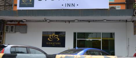 Placa de hotel com o nome "Signature Inn" e um logotipo.