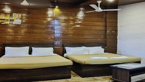 Quarto com duas camas, paredes de madeira e ventiladores no teto.
