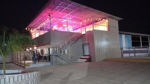 Um edifício com fachada em azulejos, escadas e uma área coberta com luzes de corda.