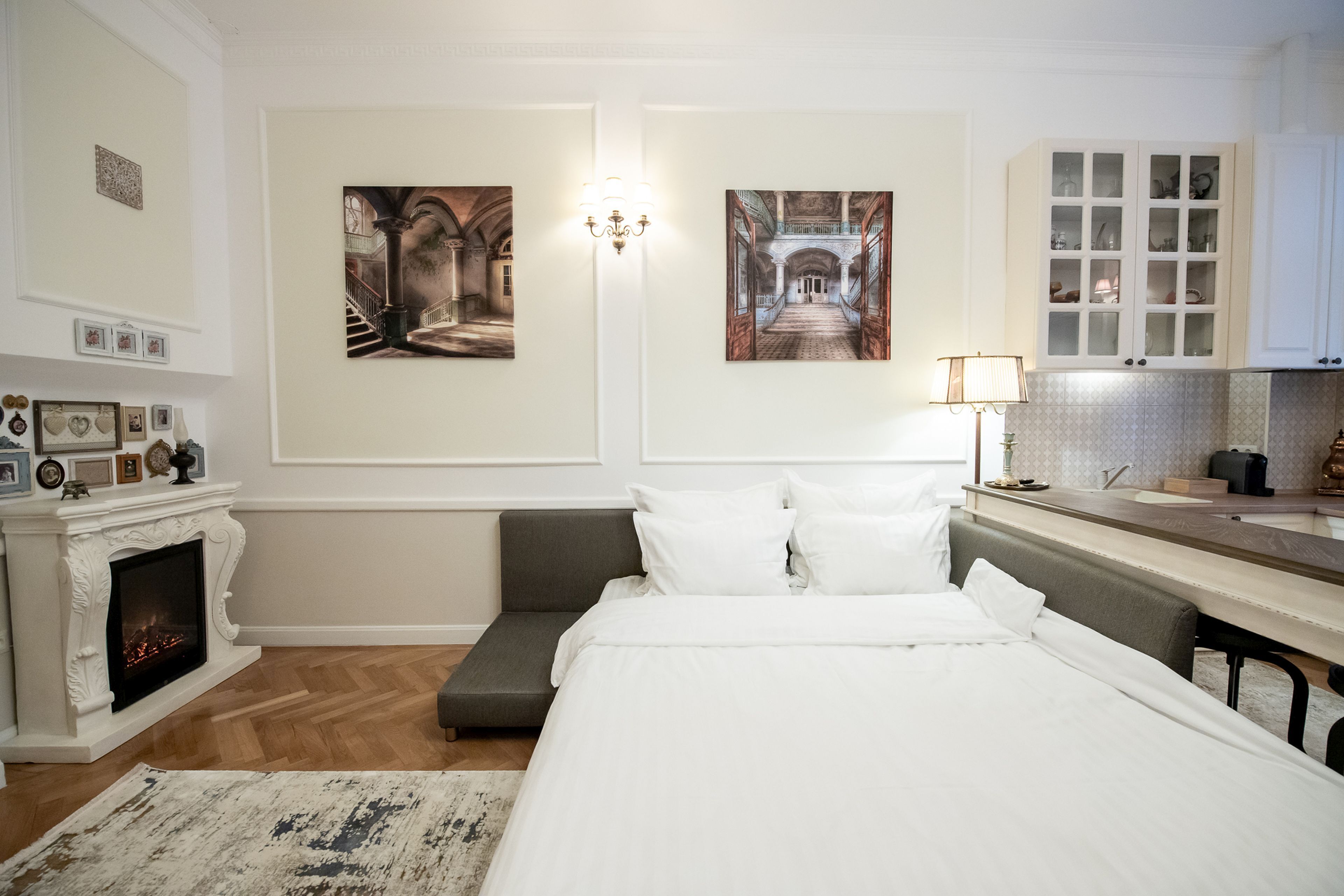 Quarto com lareira, uma cama, um banco e um espaço de jantar com abajur.