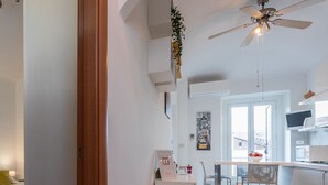 Uma cozinha moderna com área de refeições, ventilador de teto e vista para o exterior.