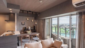 Uma sala de estar moderna com sofá, mesa de jantar e cozinha.