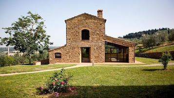 Uma casa de pedra com uma grande janela de vidro e uma porta pequena.