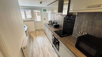 Um frigorífico/congelador grande, um micro-ondas, um forno