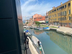 Um canal com barcos, uma bicicleta e edifícios ao longo da água.