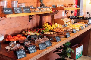 Um buffet de café da manhã com diversos alimentos e etiquetas, em um ambiente de café.